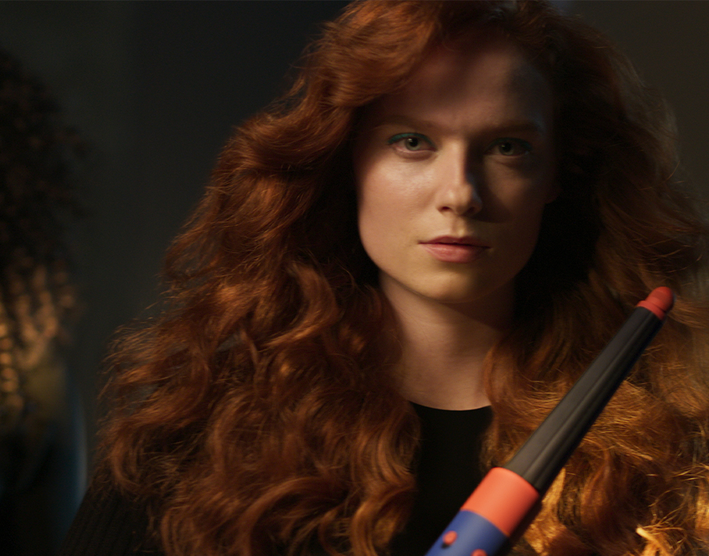 A model holding the Dyson Airwrap i.d. multi-styler and dryer.